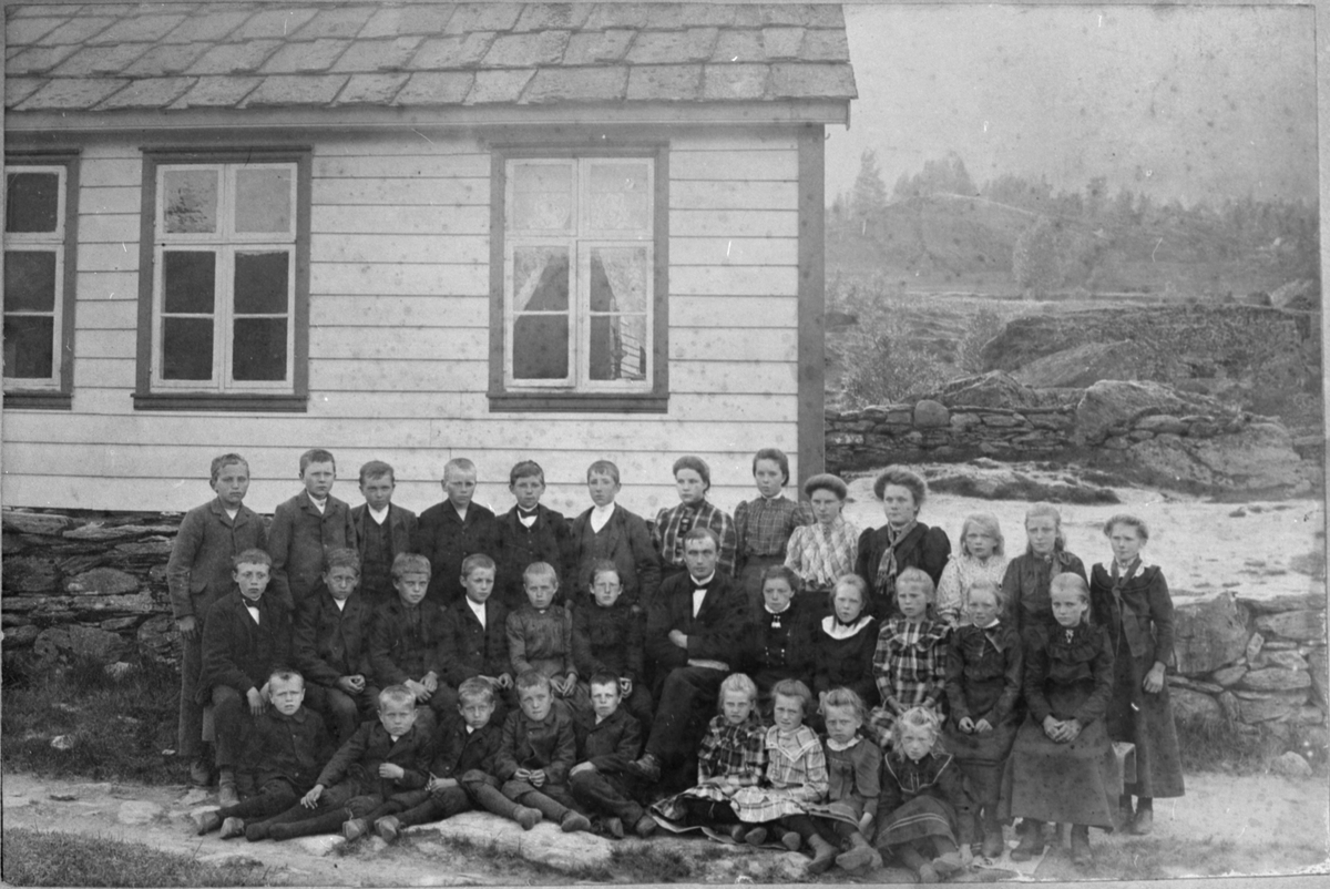 Den gamle skulen i Vågen krins i Ølen, ca. 1905. Sitjande i fremst, frå ...