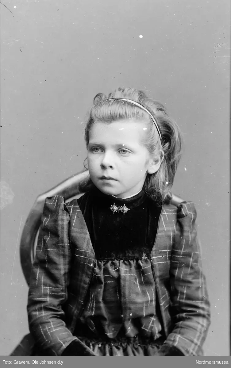 Portrett i halvfigur av en sittende jente med smykke og hårbøyle ...