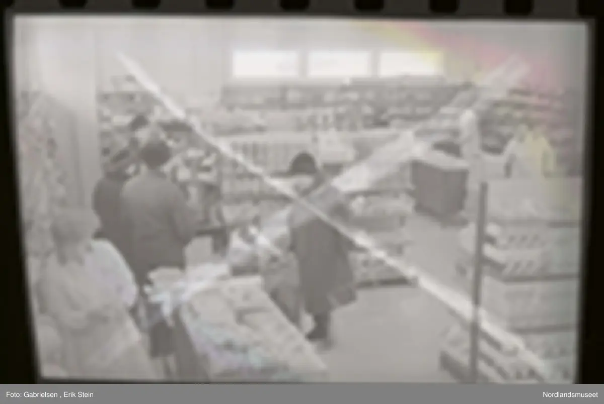 Fotografi av noen kvinner og menn og et barn kledd i vinterklær som ...