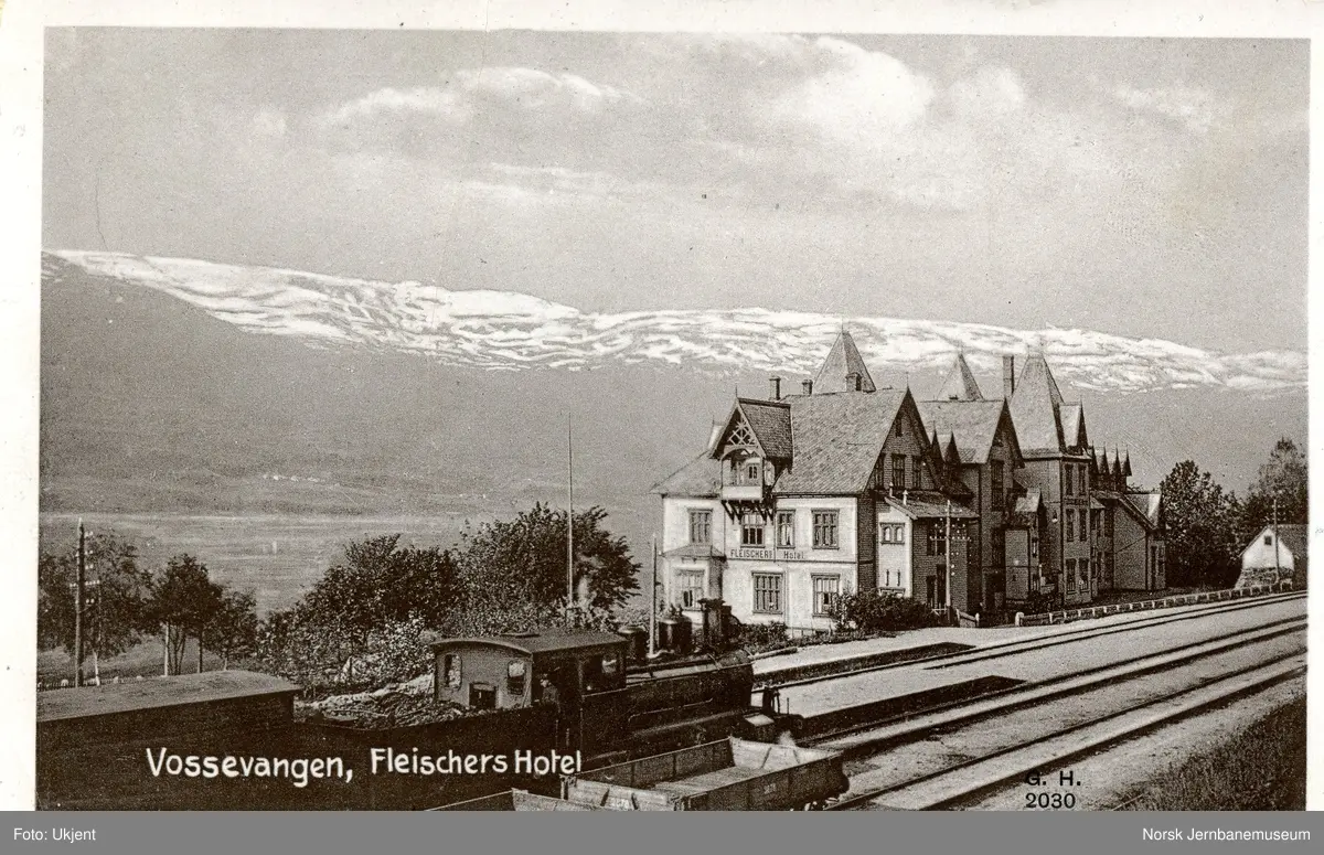 Damplokomotiv type 21a på Voss stasjon. Bak til høyre Fleischers Hotel ...