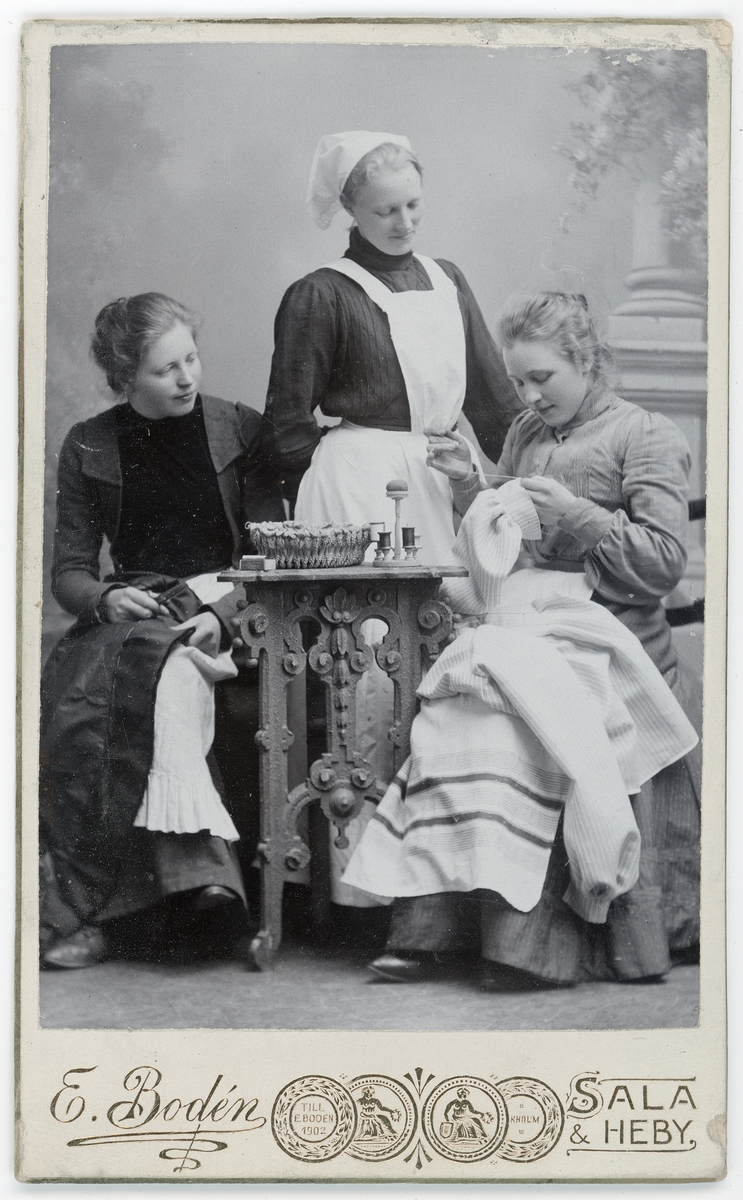 Kabinettsfotografi - tre kvinnor varav två sitter och syr, Sala ...