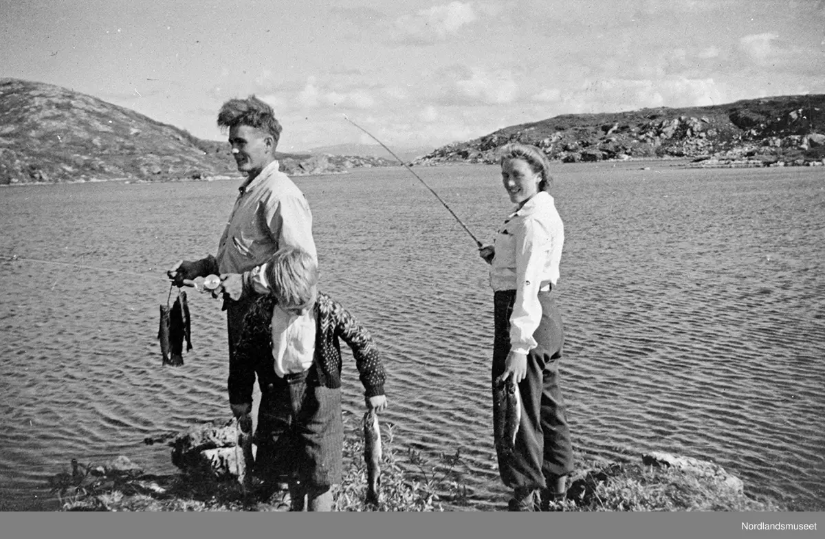 En mann med fiskestang, han holder tre fisker. En dame med fiskestang ...