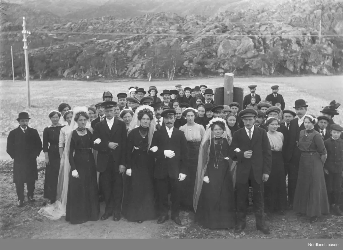 Gruppebilde. 3 brudepar med gjester. De tre brudene er kledd i mørke ...