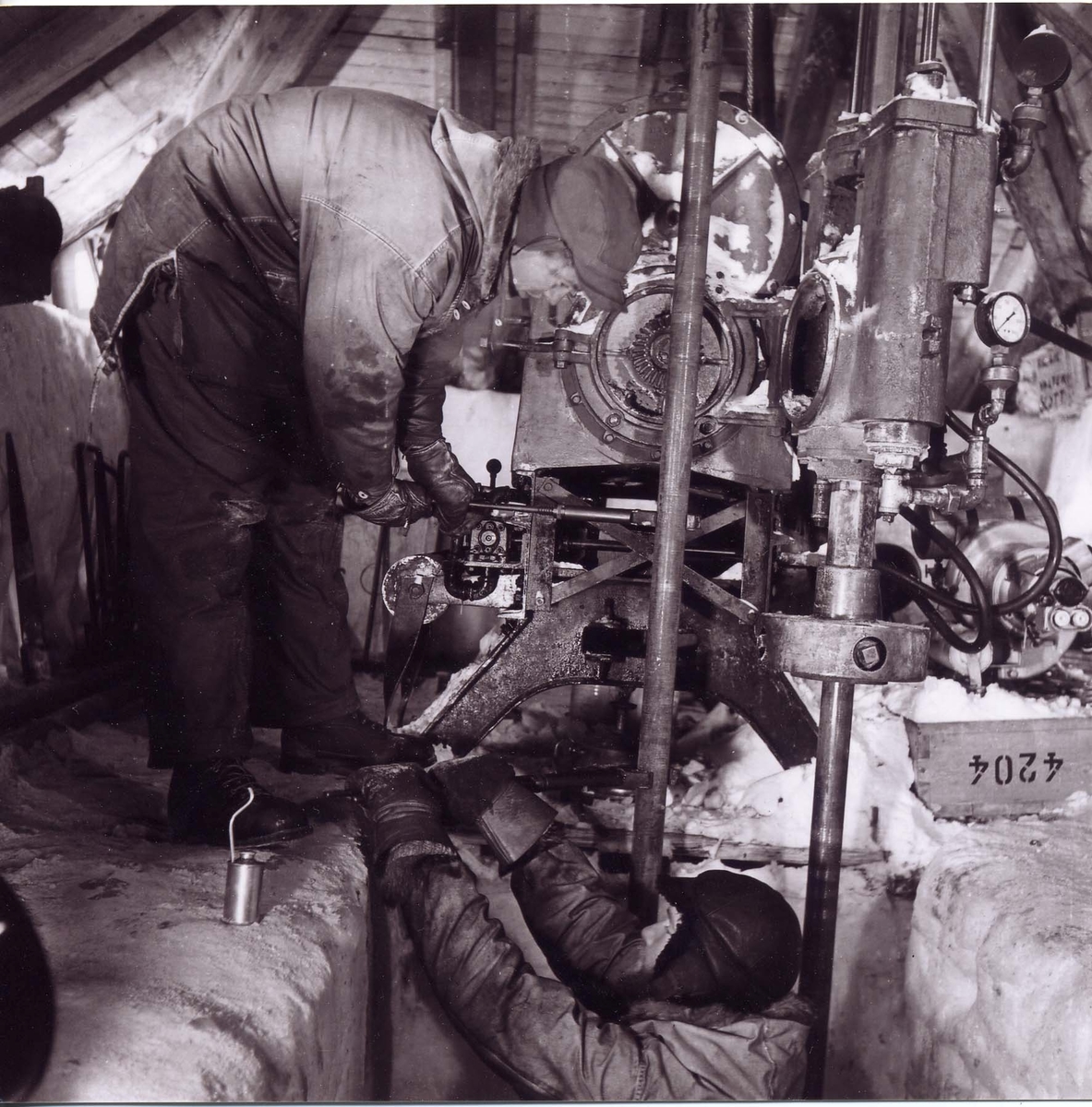 "Borrmaskin i borrhytta. Valter Schytt och Charles Swithinbank i gropen ...