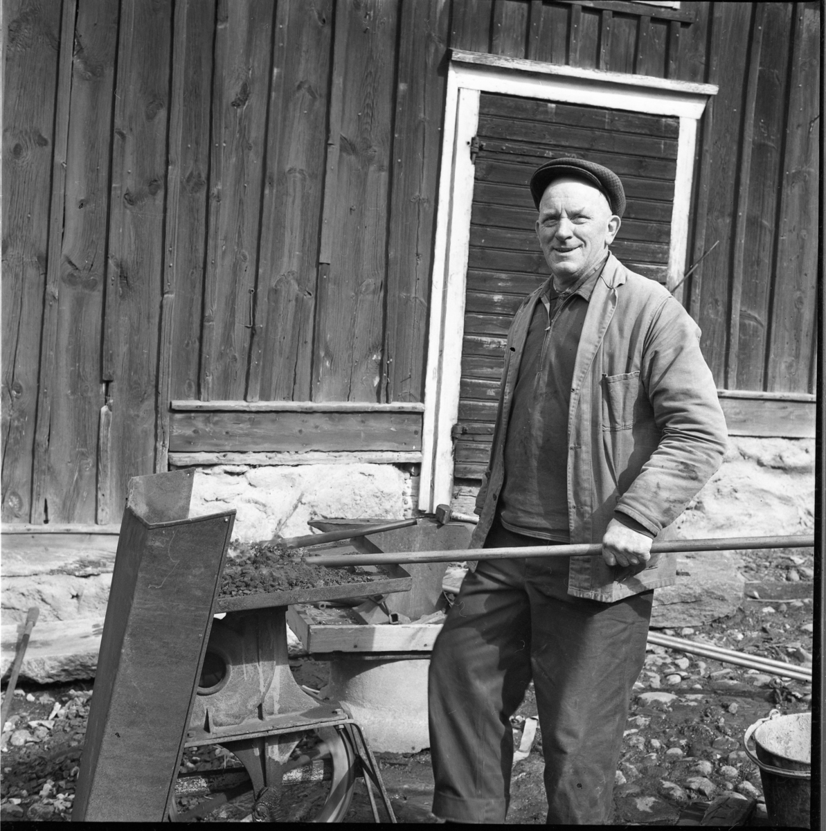 Carl Wall står och arbetar vid en mobil ässja utanför en ekonomibyggnad ...