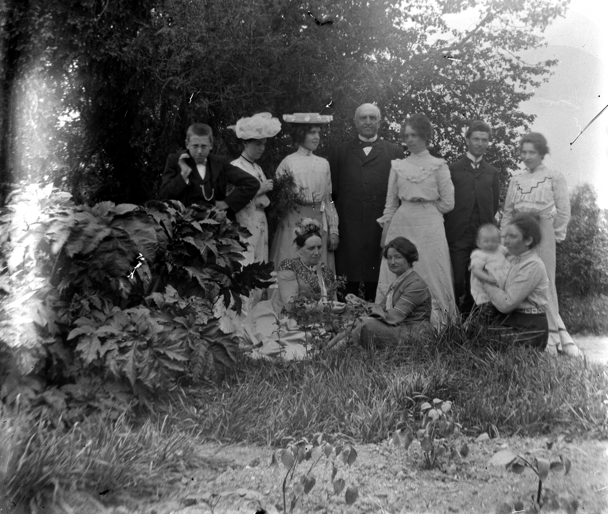 Familiegruppe i hagen på Hovinsholm gård, Helgøya i Ringsaker. Ukjente ...
