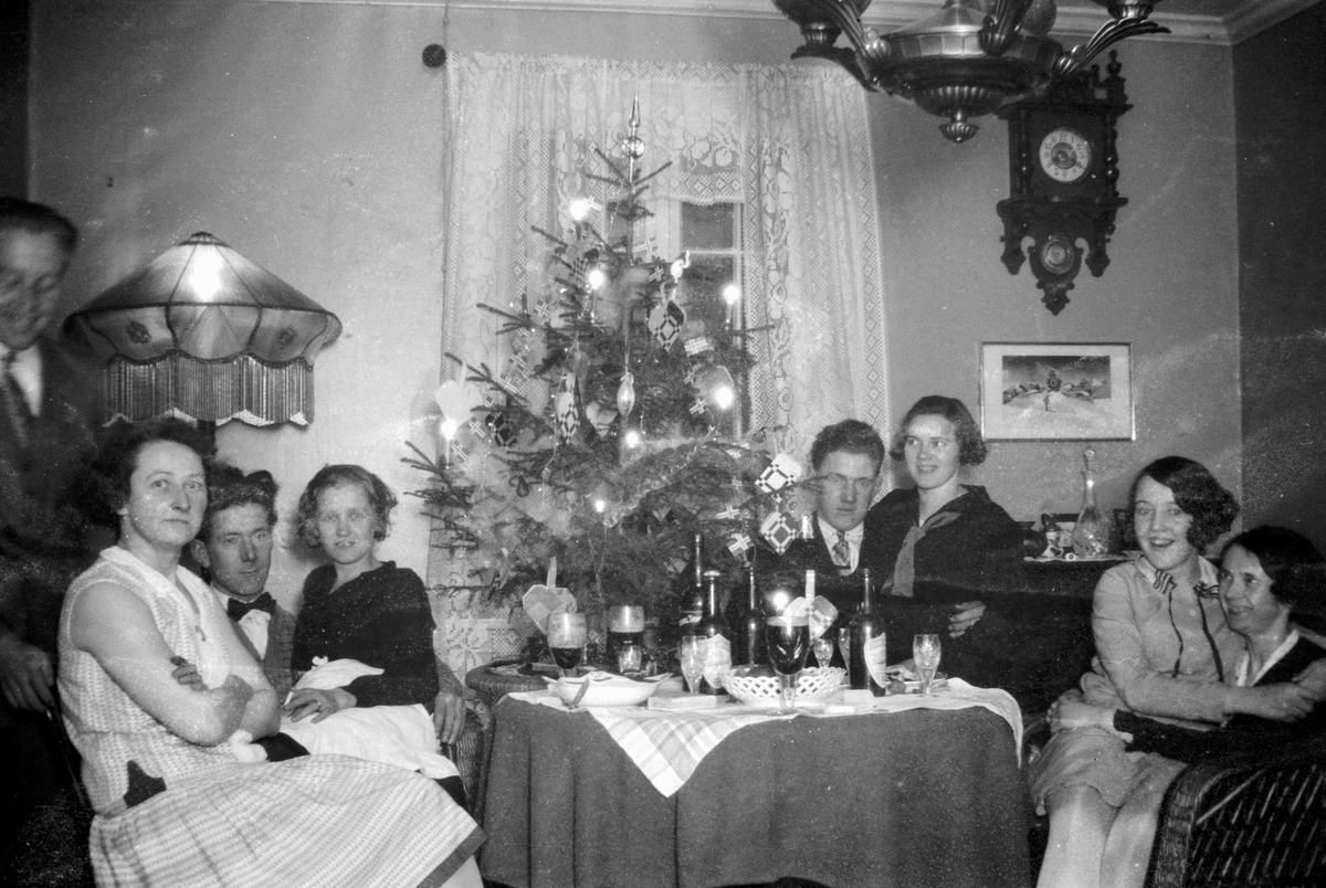 Julefeiring med vin. Åtte personer samlet rundt et spisestubord ...